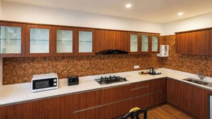 Uma cozinha moderna com armários de madeira, micro-ondas, fogão e pia.