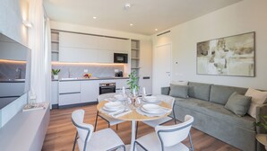 A modern kitchen with white cabinetry, a built-in oven, and a microwave.
