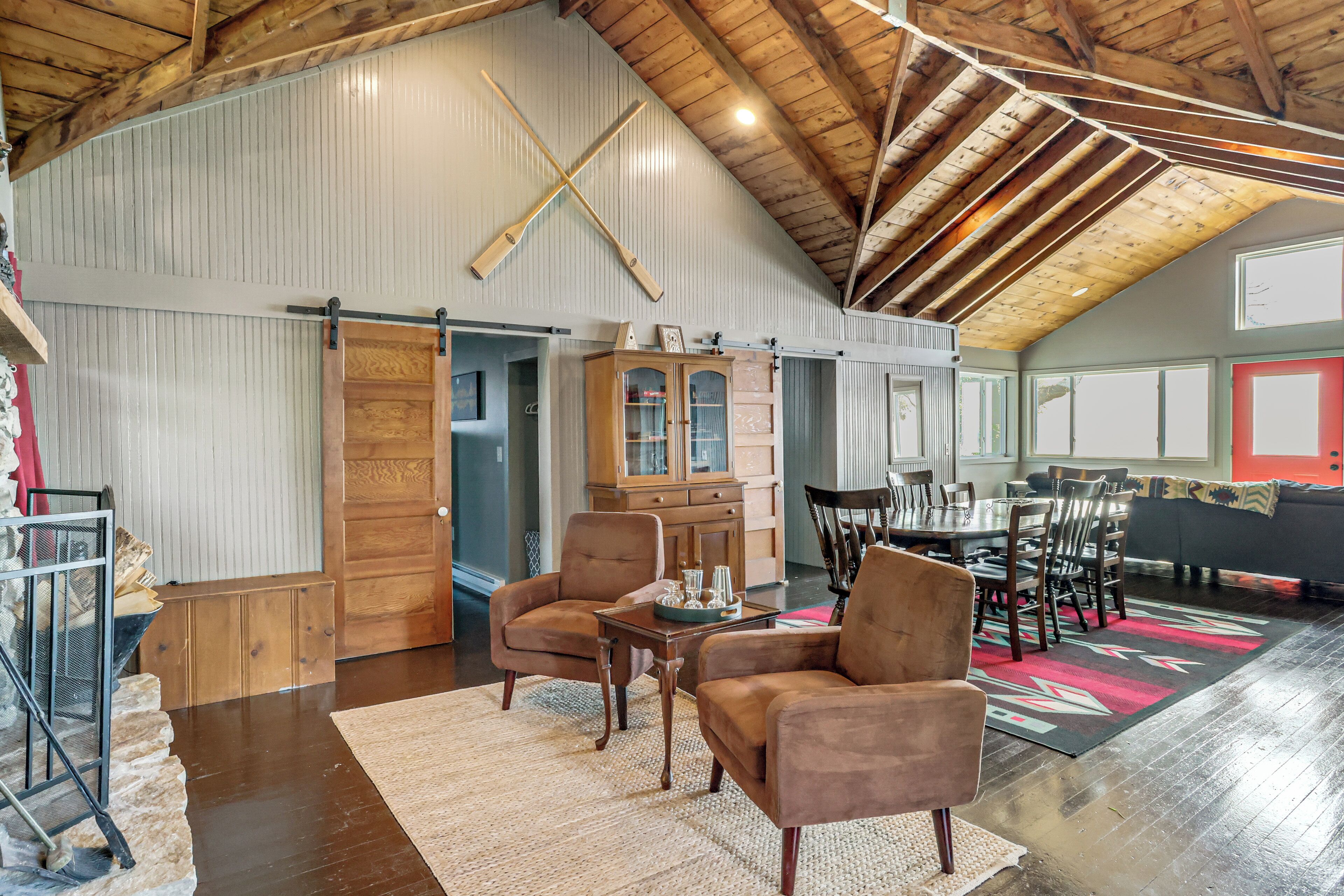 Um loft espaçoso com pé direito alto, vigas de madeira aparentes e uma ampla área de jantar.