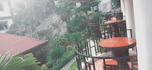 Uma varanda com vista para um penhasco rochoso e vegetação exuberante.