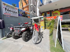 Uma motocicleta estacionada em frente a um edifício com uma placa indicando uma farmácia.