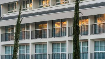 Um hotel com vários andares, varandas e grandes janelas.
