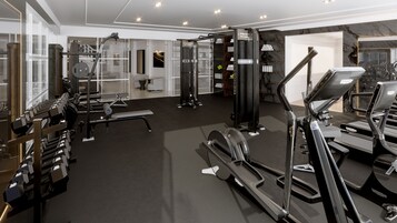 Academia moderna com diversos equipamentos de exercício, incluindo esteiras e aparelhos de musculação.