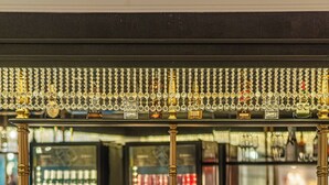 Uma área de bar com dois bancos e um detalhe decorativo no teto.