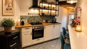 Uma cozinha moderna com forno embutido, máquina de café e geladeira preta.