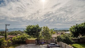 Zona residencial com casas, um carro estacionado e um portão.