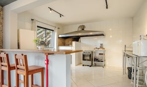 Cozinha moderna com ilha central, fogão e micro-ondas.