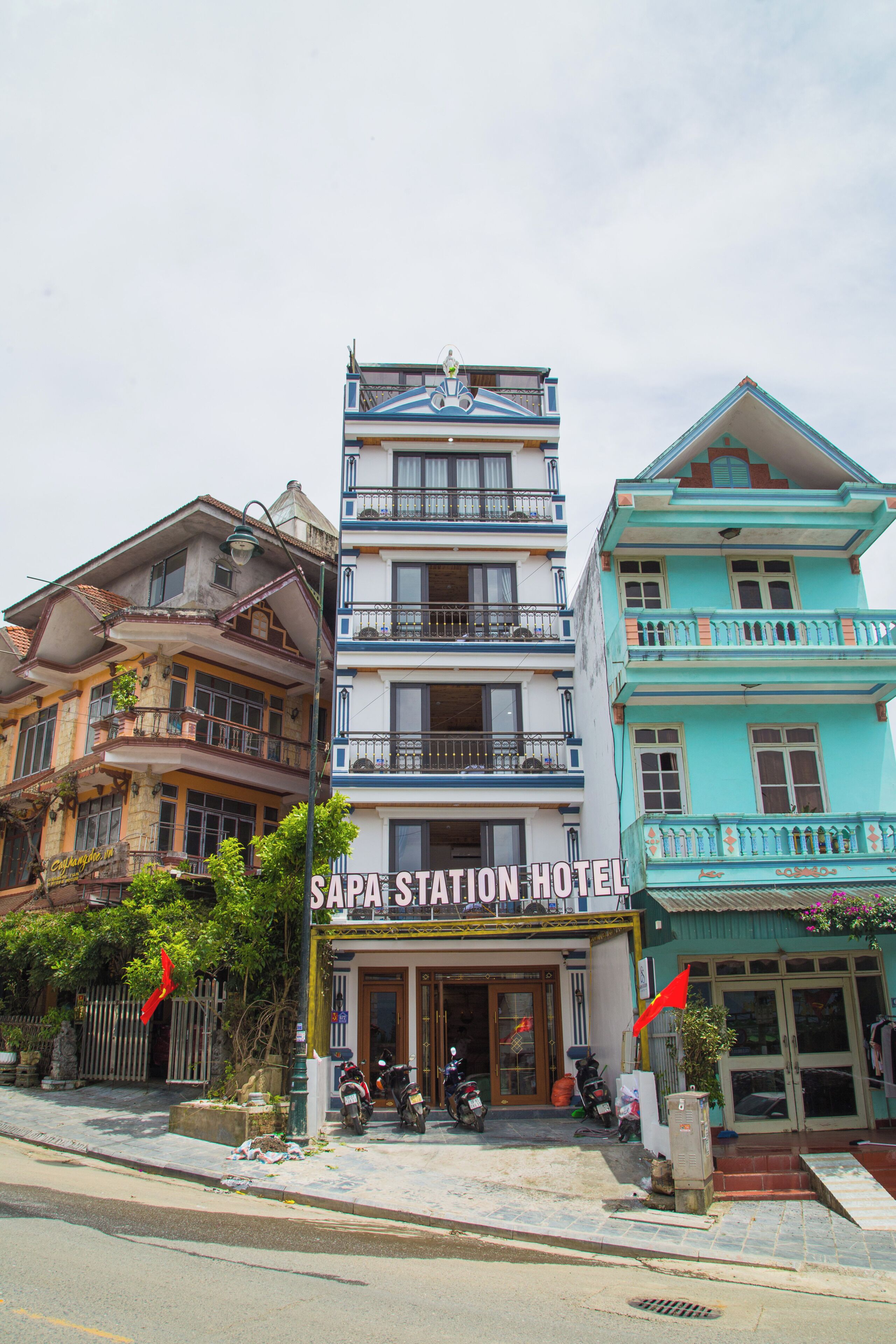 Um edifício de vários andares com uma placa indicando 'Sapa Station Hotel'.