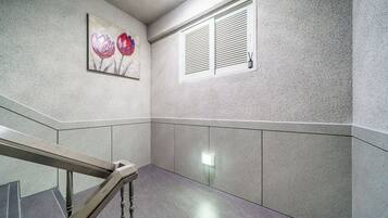 Interior moderno com escada, um respiradouro fixado na parede e um quadro.