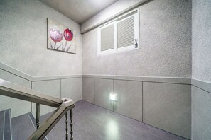 Interior moderno com escada, um respiradouro fixado na parede e um quadro.