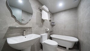 A modern bathroom with a sink, toilet, and bathtub.