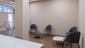 Um interior moderno com área de estar, uma mesa e vista para uma varanda.