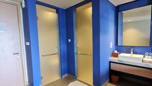Casa de banho com parede azul, pia branca e espelho.
