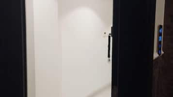 Corredor com piso claro e porta com fechadura digital.