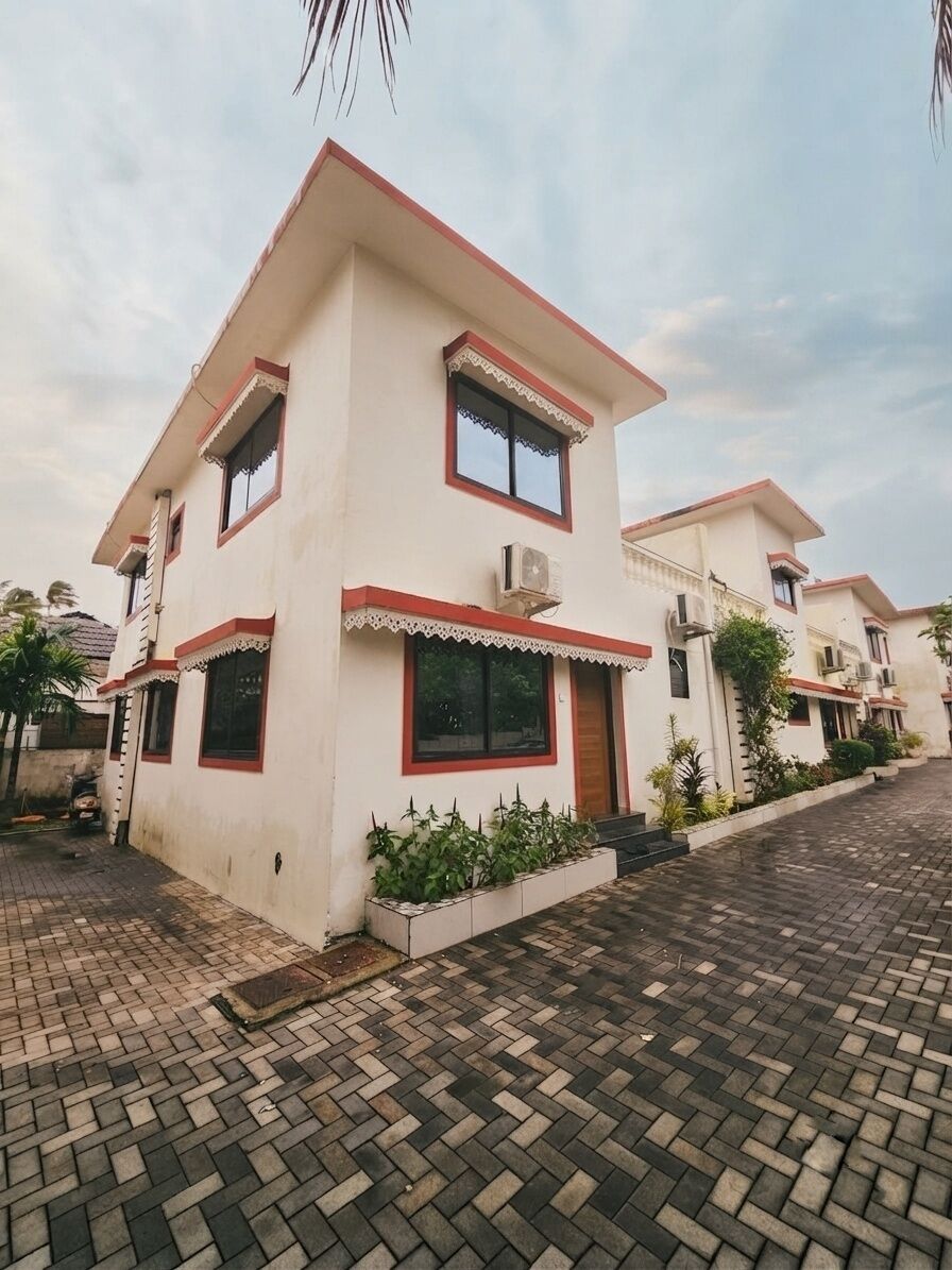 Um edifício residencial de dois andares com telhado plano, entrada central e acesso pavimentado.
