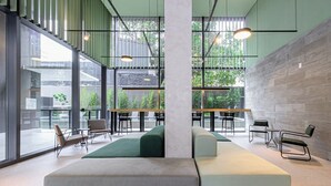 Um interior moderno com uma área de estar central, grandes janelas e uma parede de pedra.