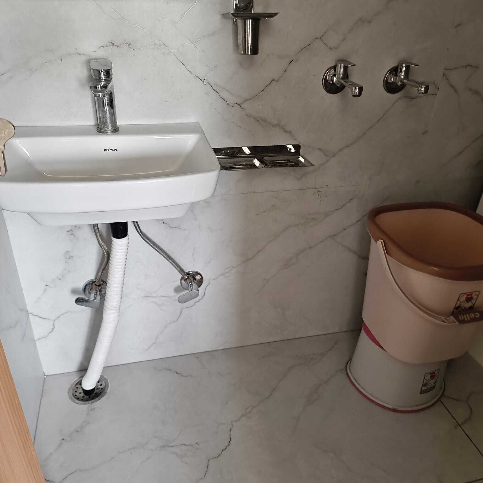Um banheiro com pia branca, vaso sanitário e bidê.