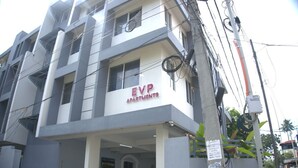 Um edifício de vários andares com uma placa indicando 'EVP Apartments', identificando-o como um imóvel residencial.