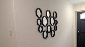 Um corredor com chão em mosaico e um conjunto de espelhos fixados na parede.