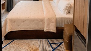 Quarto de hotel com cama, um quadro, um guarda-roupa e um aparelho de ar condicionado.