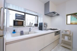 Cozinha moderna com micro-ondas, cafeteira e fogão a gás.