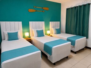 Quarto de hotel com duas camas, paredes verde-água e uma decoração com remo de madeira.