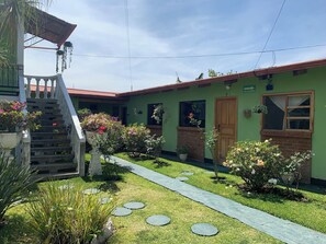 Um edifício verde com escadas, uma parede de tijolos e uma janela.