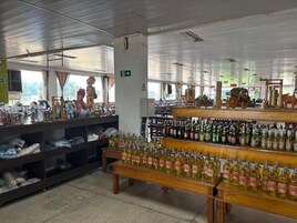Interior de loja com prateleiras repletas de diversos produtos, incluindo garrafas e caixas.