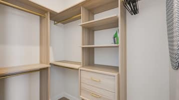 Um closet amplo com prateleiras abertas, uma barra para pendurar roupas e um módulo de gavetas.