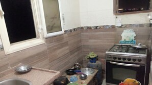 Uma cozinha compacta com fogão a gás, forno e pia.