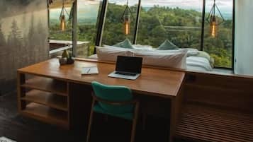 Um quarto moderno com um claraboia, uma escrivaninha com um laptop e vista para o exterior.