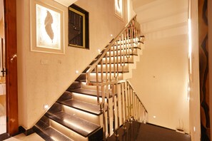 Escadaria com guarda-corpo de metal e luminária em cada degrau.