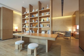 Uma biblioteca moderna com estantes de madeira, uma mesa central e áreas de estar.