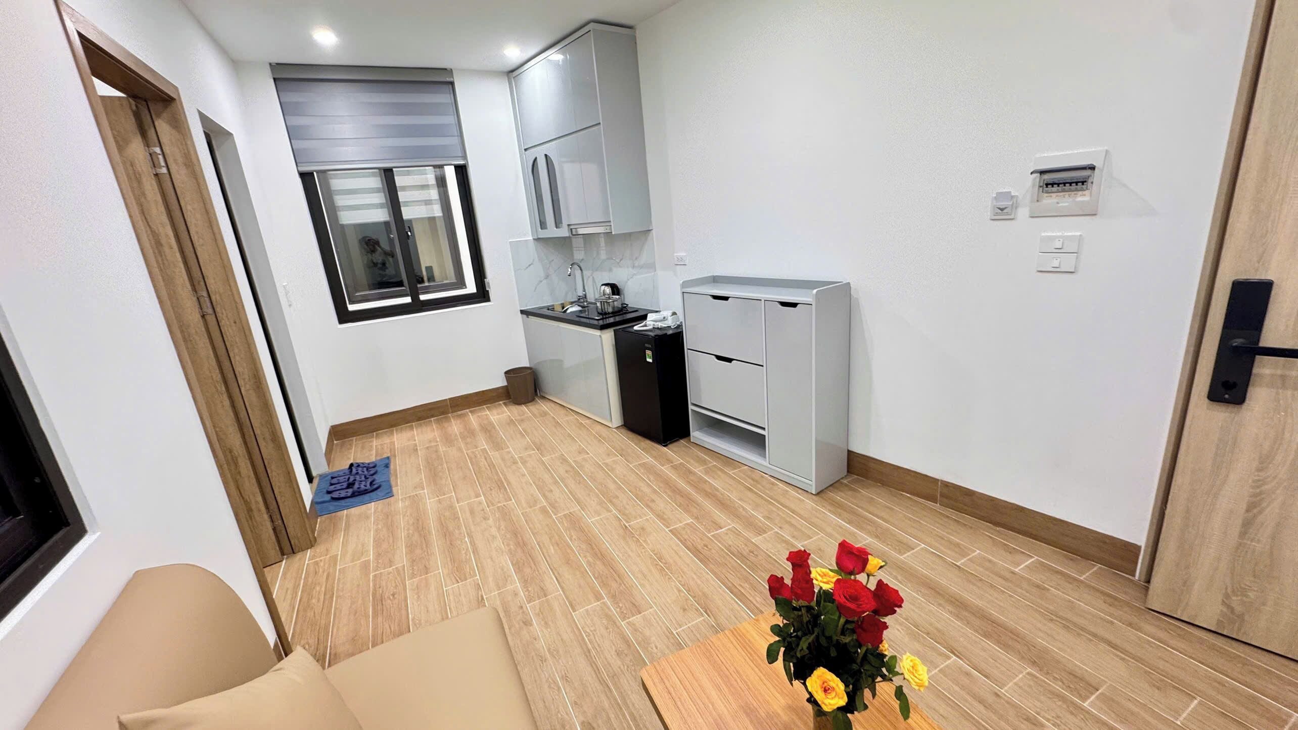 Um espaço compacto com cozinha compacta, um pequeno espaço para sentar e uma janela.