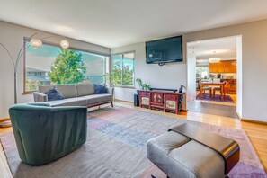 Uma sala de estar moderna com um sofá, uma mesa de centro e uma televisão.