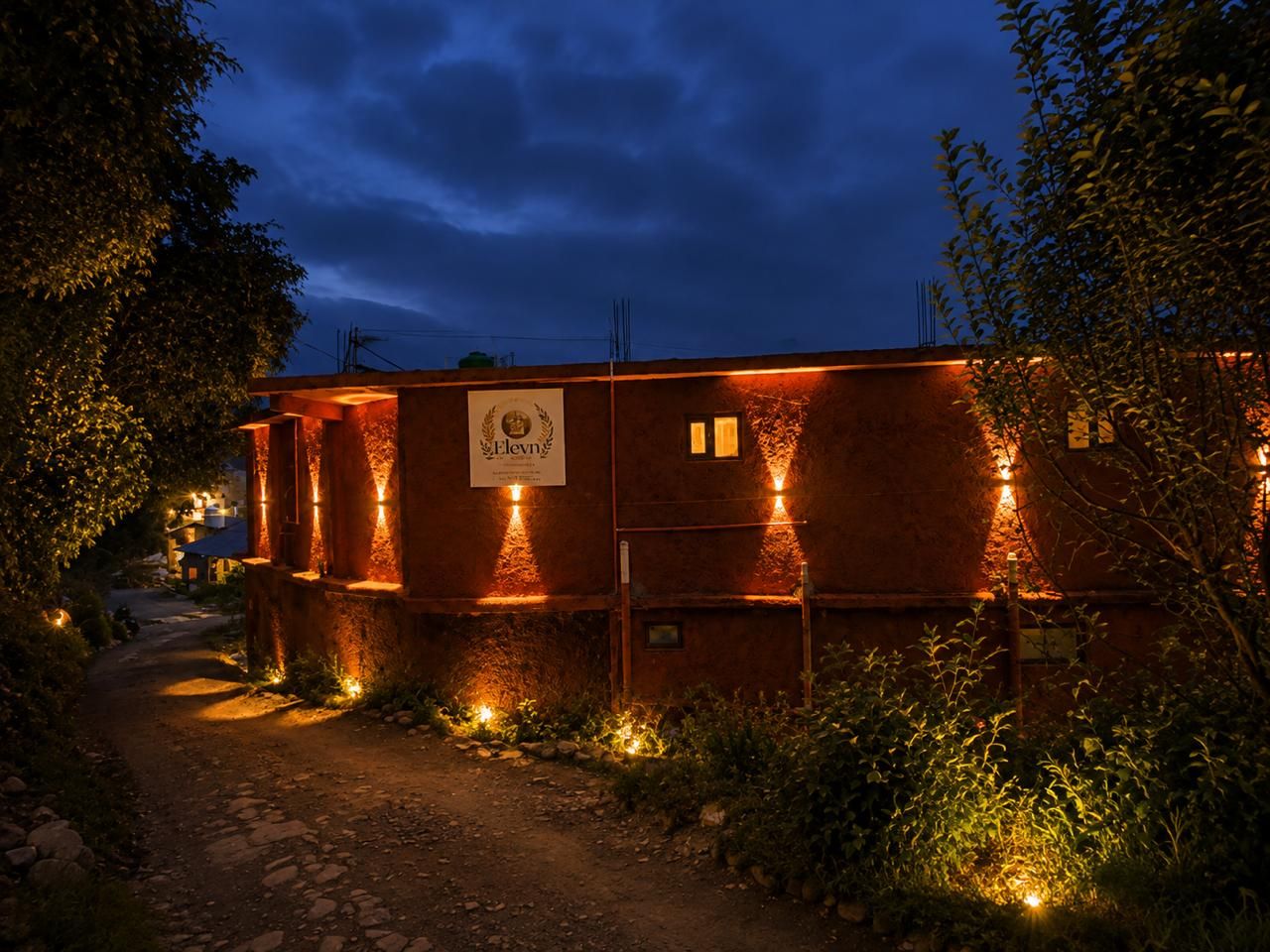 Um edifício com uma placa que diz 'Elevon' e uma trilha de terra que leva até ele.