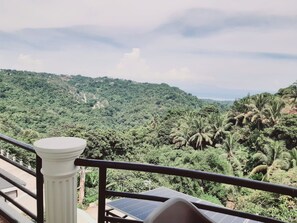 Varanda com vista para uma paisagem verdejante e painéis solares.