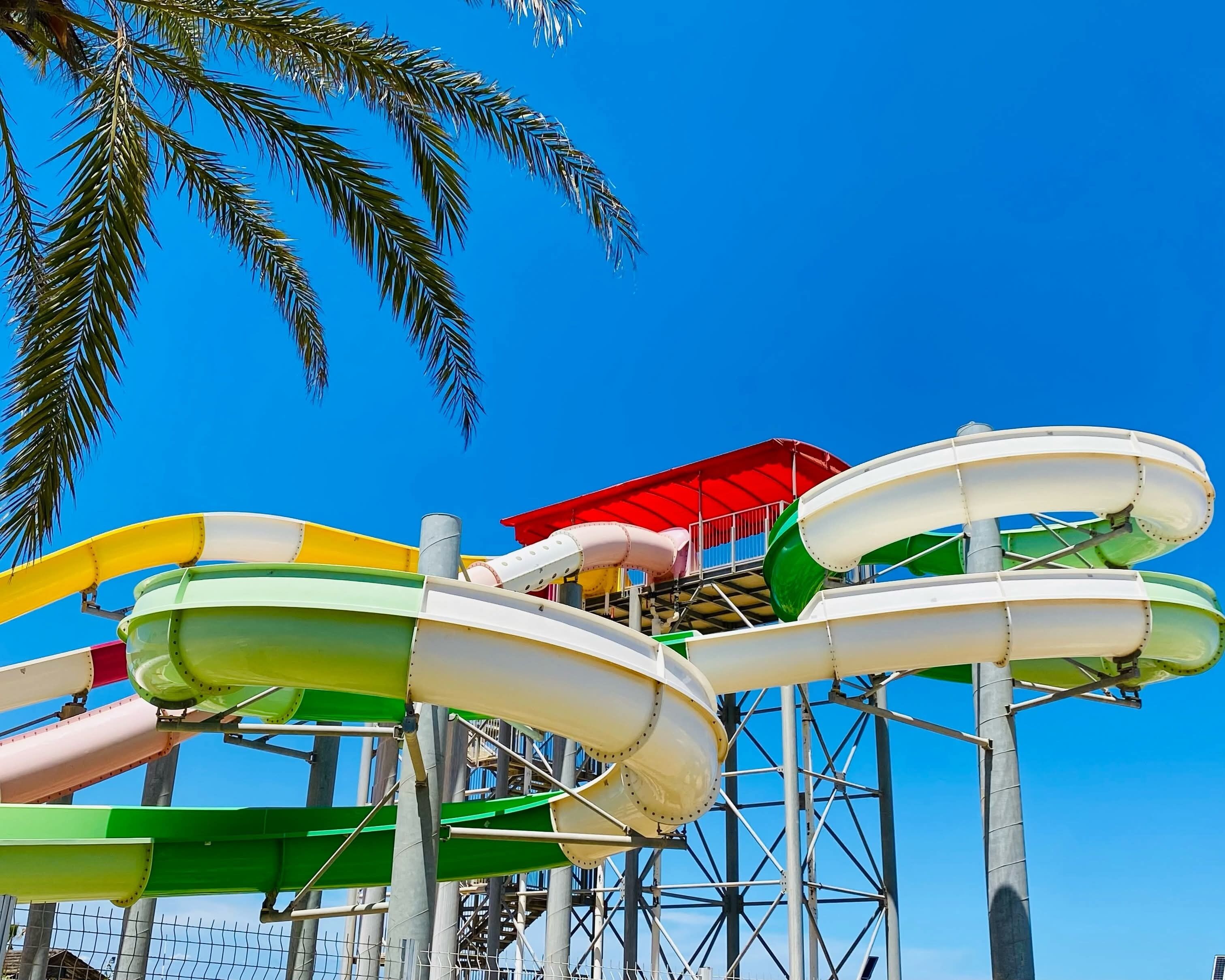 Parque aquático com várias escorregas coloridas.