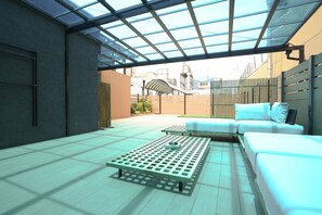 Um espaço ao ar livre moderno com teto de vidro, sofá branco e mesa de metal.