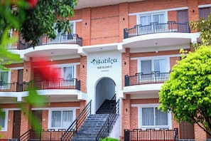 Um edifício de vários andares com uma placa que diz 'Batik Resort'.