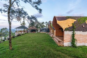 Um resort com cabanas de madeira, um gazebo e um gramado.