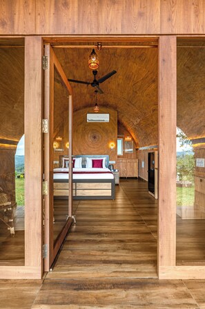 A spacious room with a large bed, a ceiling fan, and a view of the outdoors.