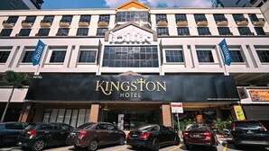 Um edifício de hotel com uma placa de destaque para 'Kingston Hotel' e várias bandeiras.