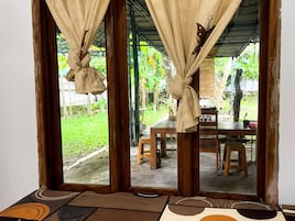 Quarto com vista para área externa, incluindo uma mesa e cadeiras.