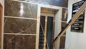 Um interior moderno com uma parede de mármore, uma escadaria e um letreiro neon.