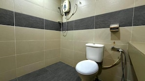 Um banheiro pequeno com vaso sanitário, chuveiro e dispensador de toalhas.