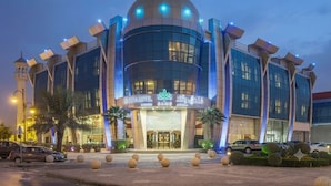 Um hotel moderno com fachada curva marcante, uma estrutura de cúpula imponente e uma entrada bem iluminada.