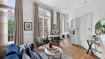 Uma sala de estar moderna com um sofá, uma mesa de centro e uma área de jantar com mesa e cadeiras.