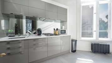 Uma cozinha moderna com uma ilha grande, eletrodomésticos de aço inoxidável e uma janela com vista.