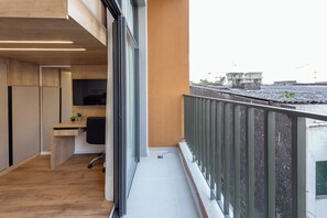 Um apartamento moderno com varanda, cozinha e vista para a cidade.